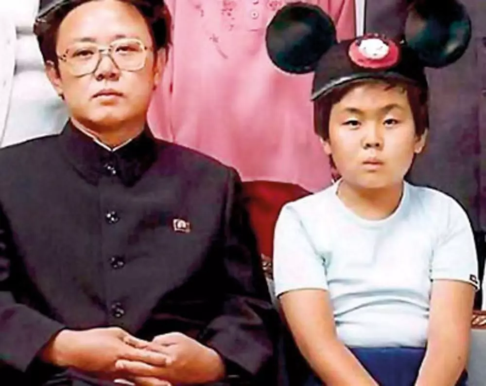 Reta nuotrauka, kurioje užfiksuotas jaunas Kim Jong-unas su tėvu ir buvusiu Šiaurės Korėjos lyderiu Kim Jong-ilu. Būsimasis lyderis, jaunystėje iškentęs bausmę, priverstas vilkėti sugedusio rytų priešo kasdienius madingus drabužius.